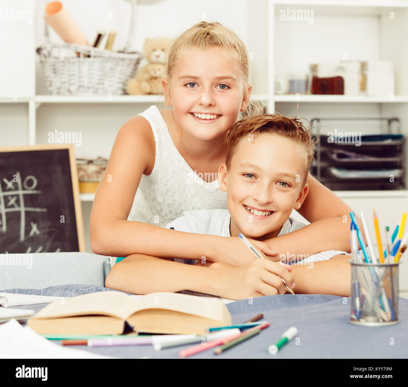 Sister is helping brother with homework at home Stock Photo - Alamy