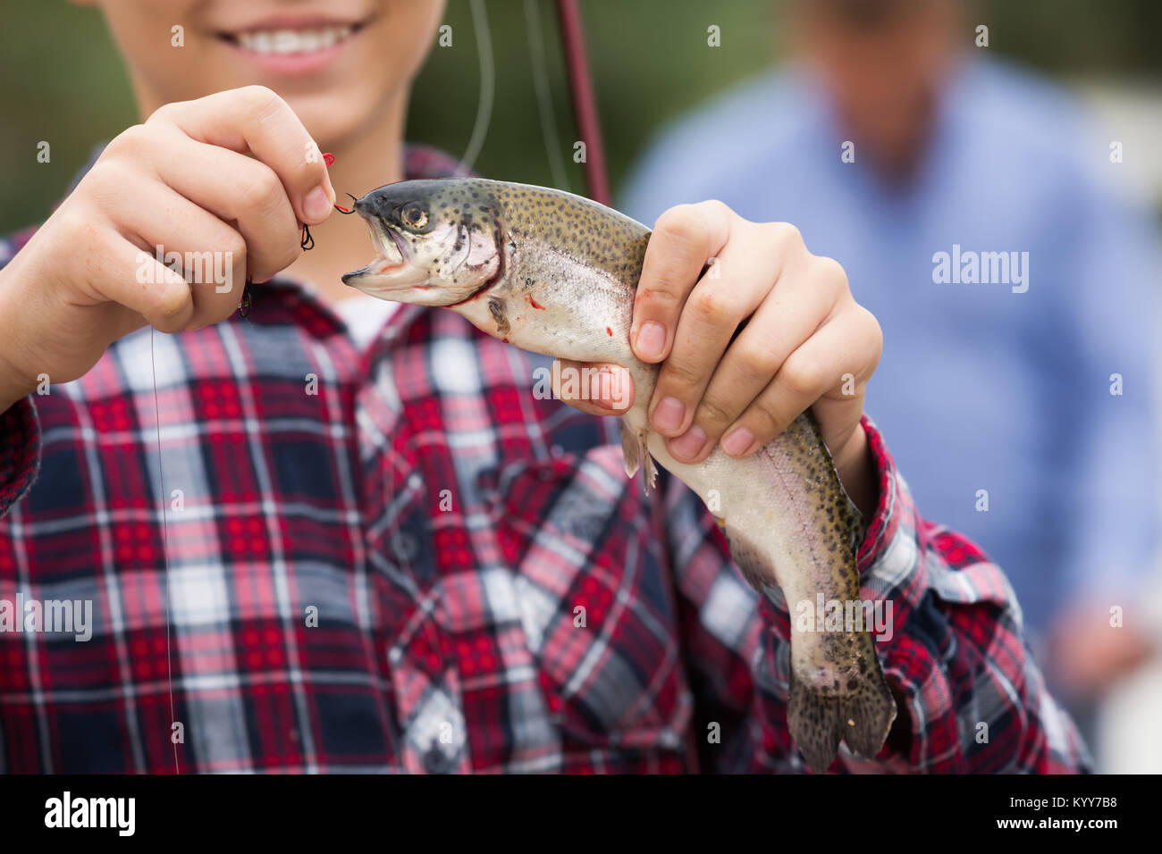 Happy teenage boy catching on hook fish on vacation Stock Photo - Alamy