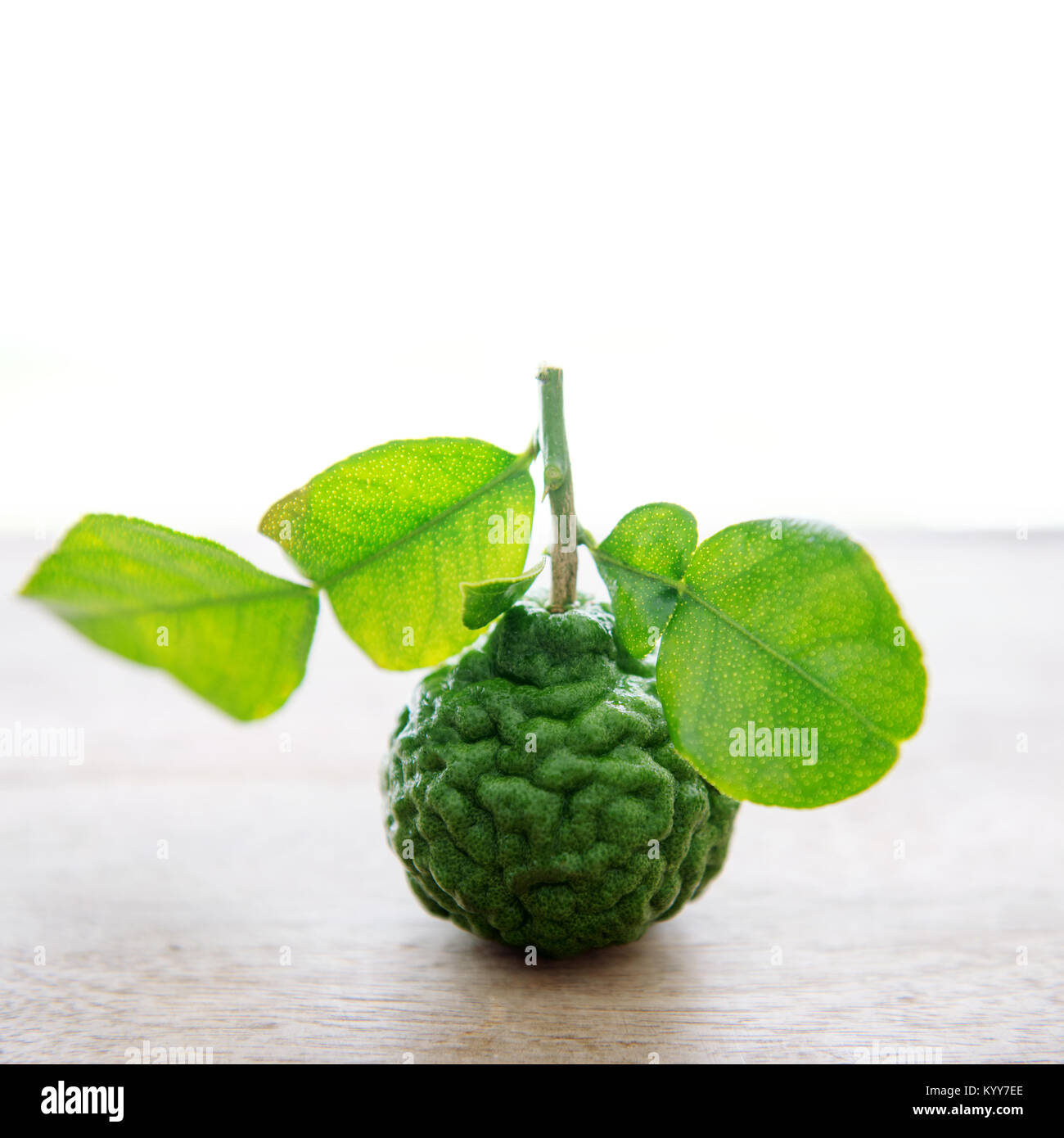 Pesticide free organic kaffir lime with leaves on wooden background ...