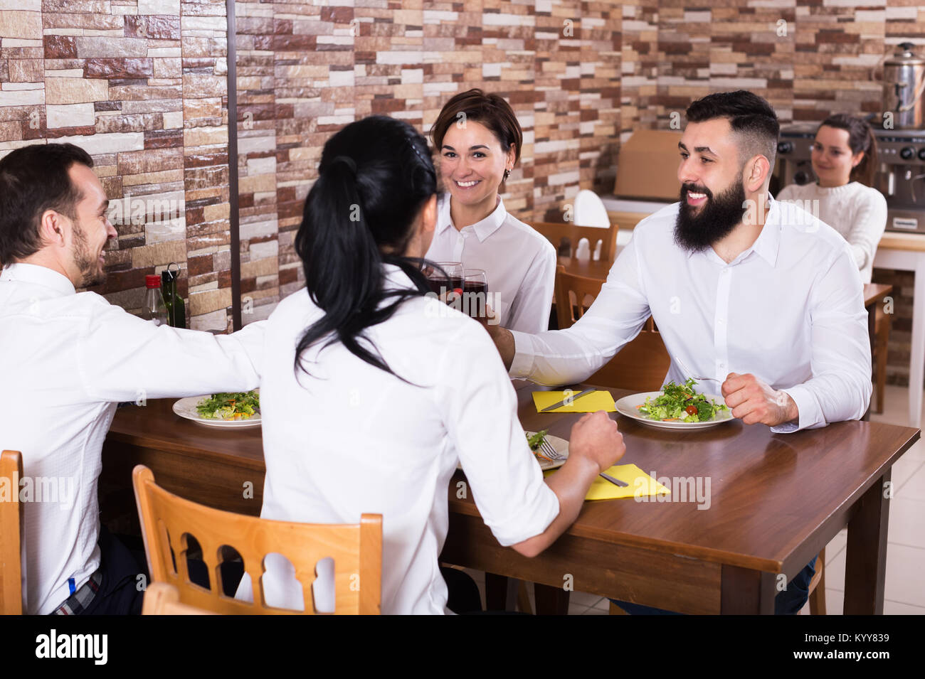 Company of friends eating dinner in traditional restaurant Stock Photo ...