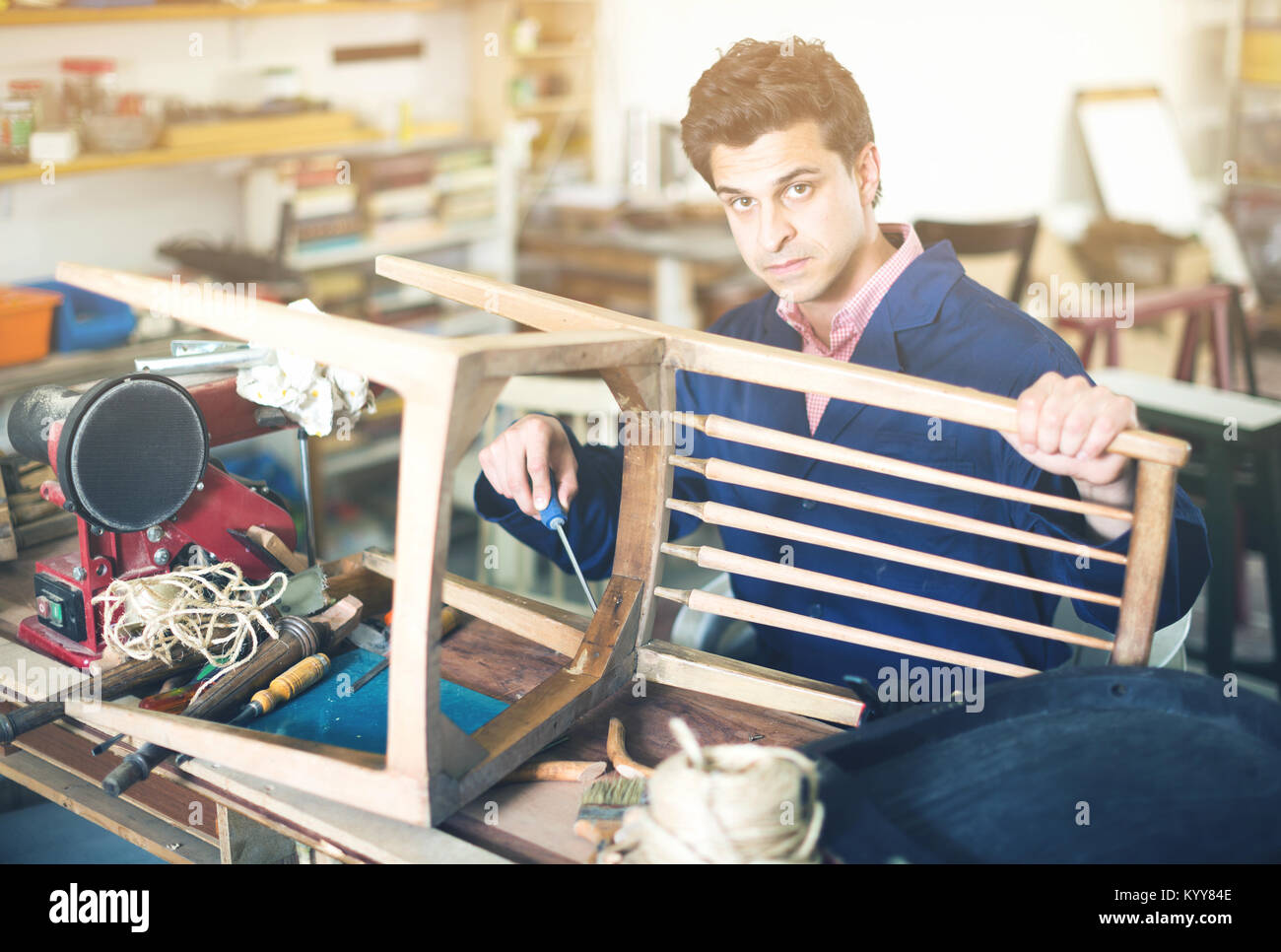 Carpenter working in repair studio and repairing broken wooden ...