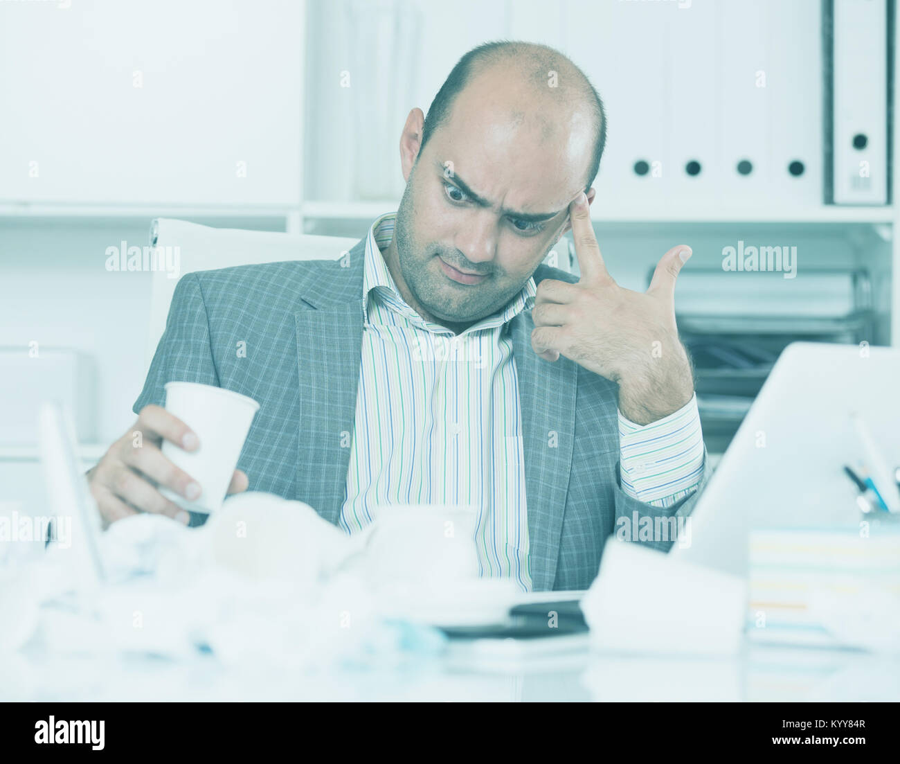 Young male having lot of work and problems in the office Stock Photo ...