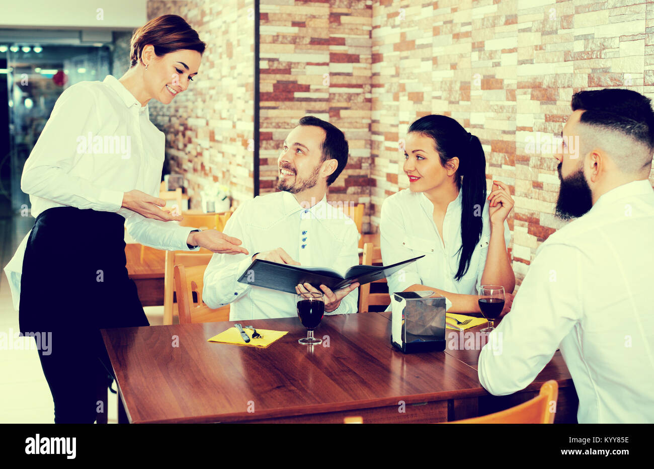 Waitress taking order at table of people having dinner together Stock ...