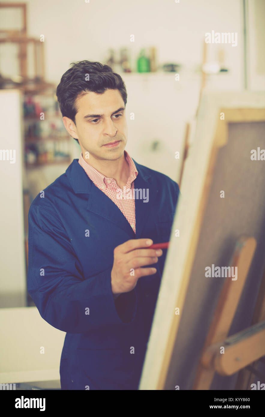 Creative male artist drawing picture with oil paints in studio Stock ...