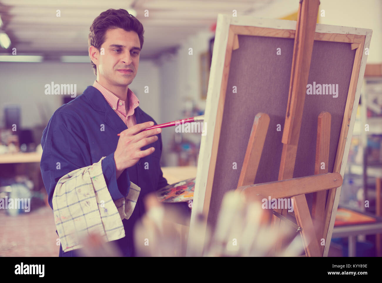 Creative male artist drawing picture with oil paints in studio Stock ...