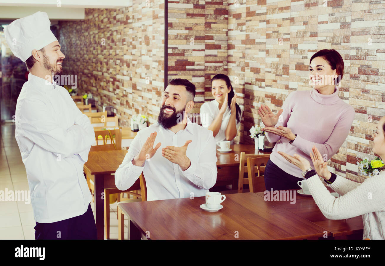 Glad cheerful positive smiling chef listens to praise of the food Stock ...