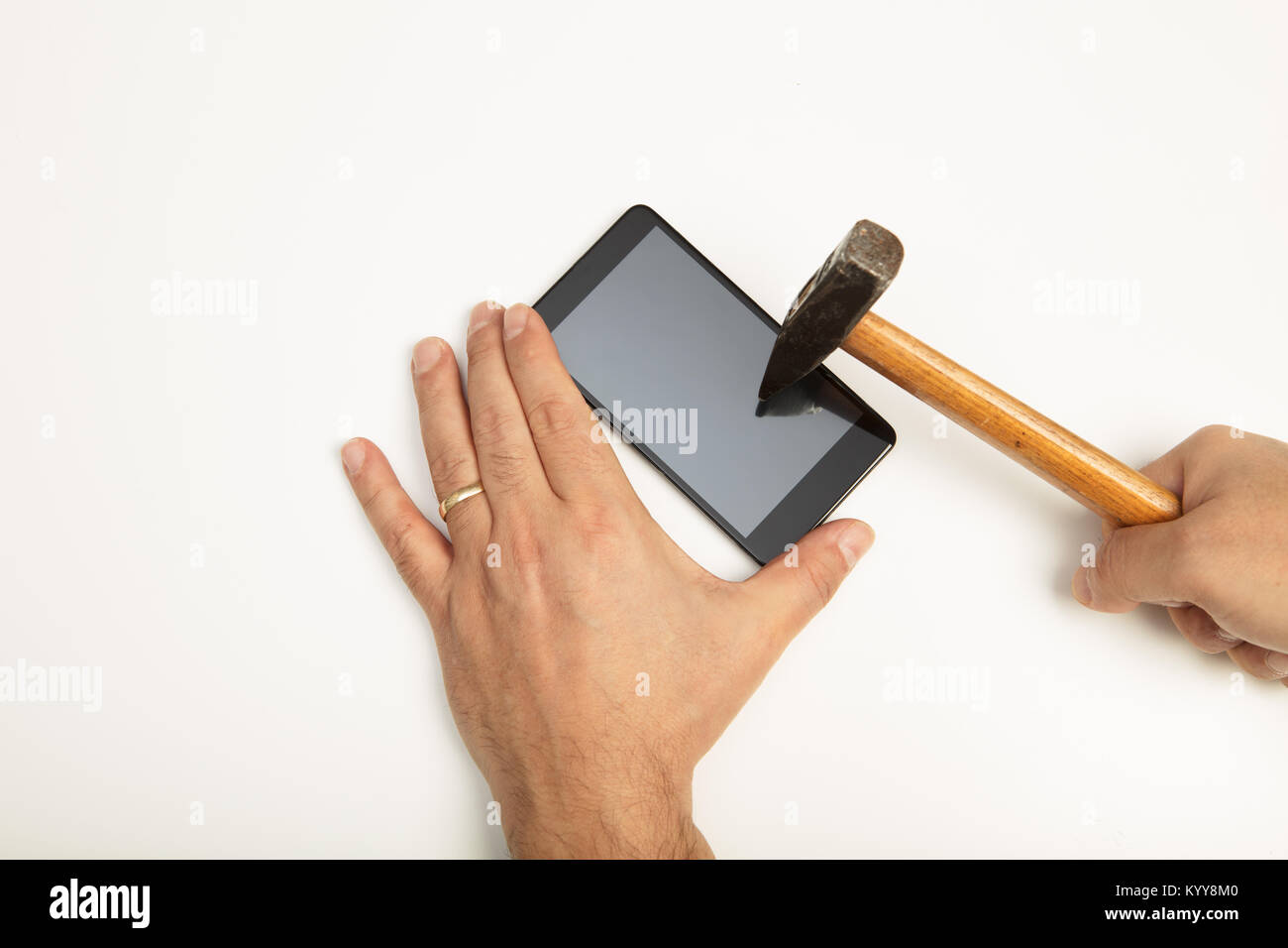 Man hitting a smartphone screen with a small mallet in a concept of ...