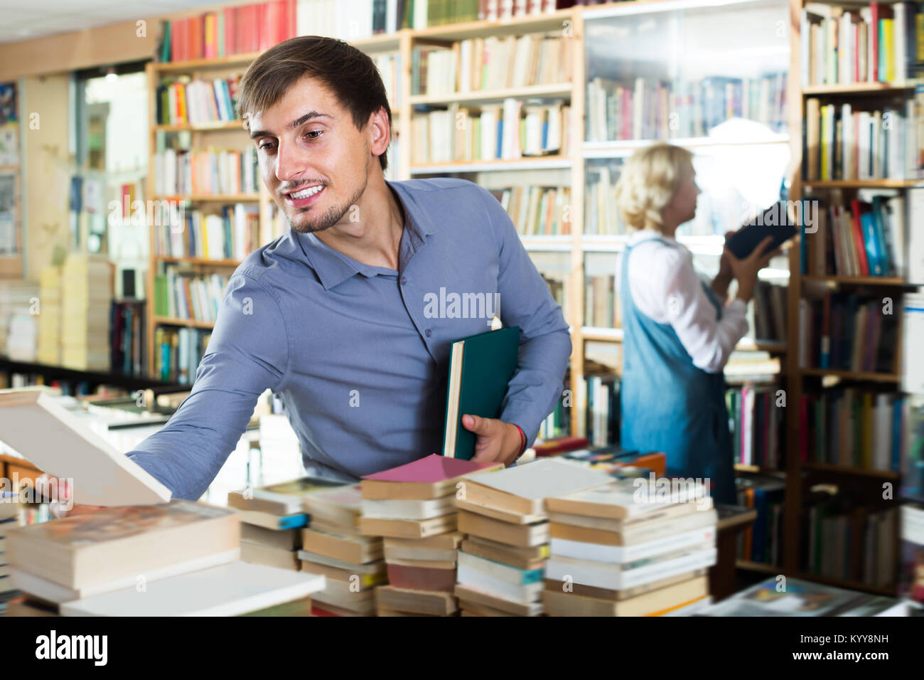Man choosing book from bookshelf hi-res stock photography and images ...