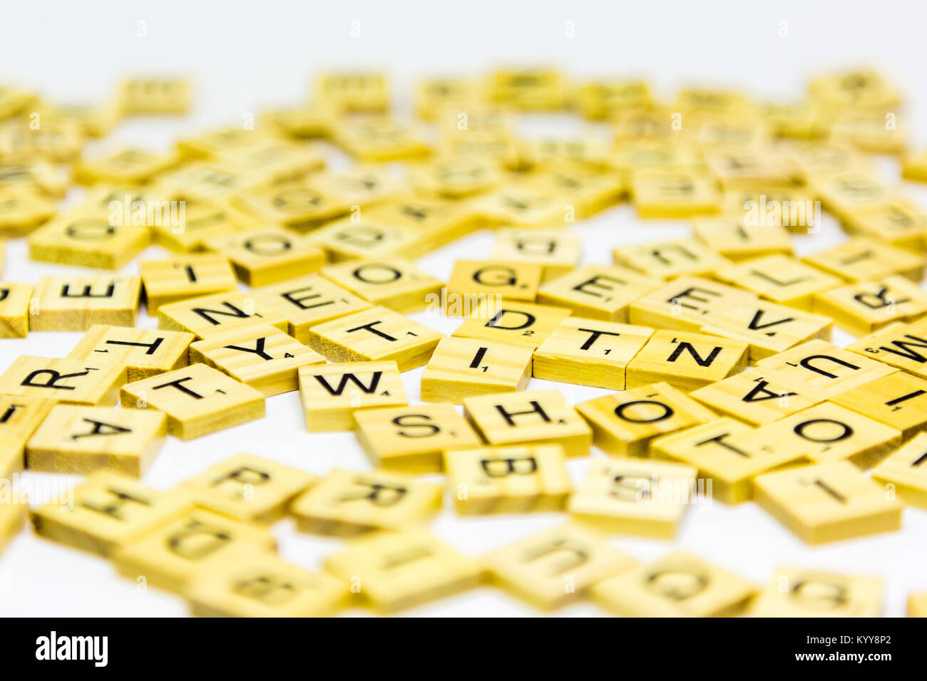 Scattered wooden scrabble letters on a white background Stock Photo - Alamy