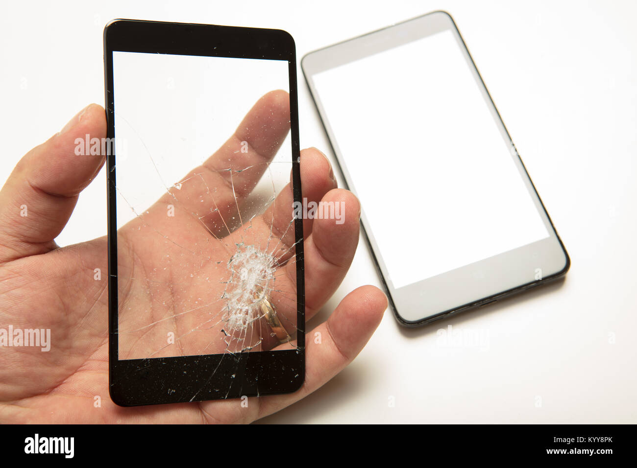 Man holding a shattered smartphone screen in his hand with the mobile ...