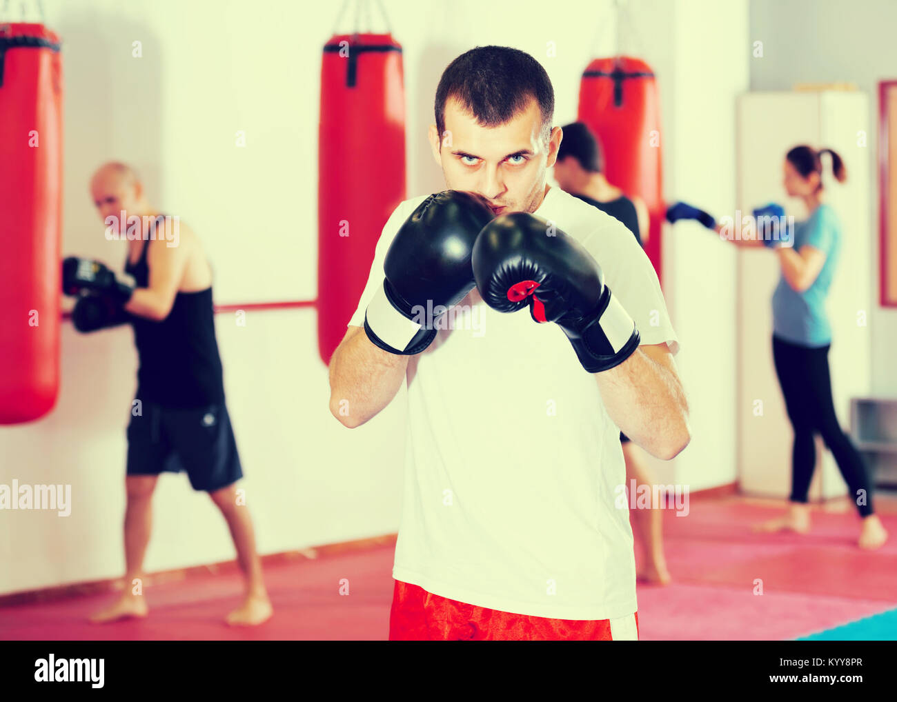 serious sportsman in the boxing hall practicing boxing punches during ...