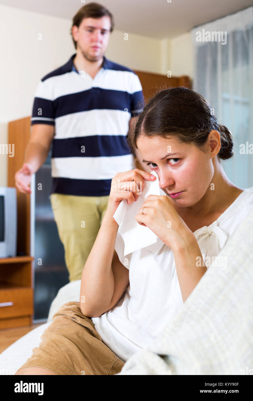 Portrait of sad young woman and man in home interior Stock Photo - Alamy