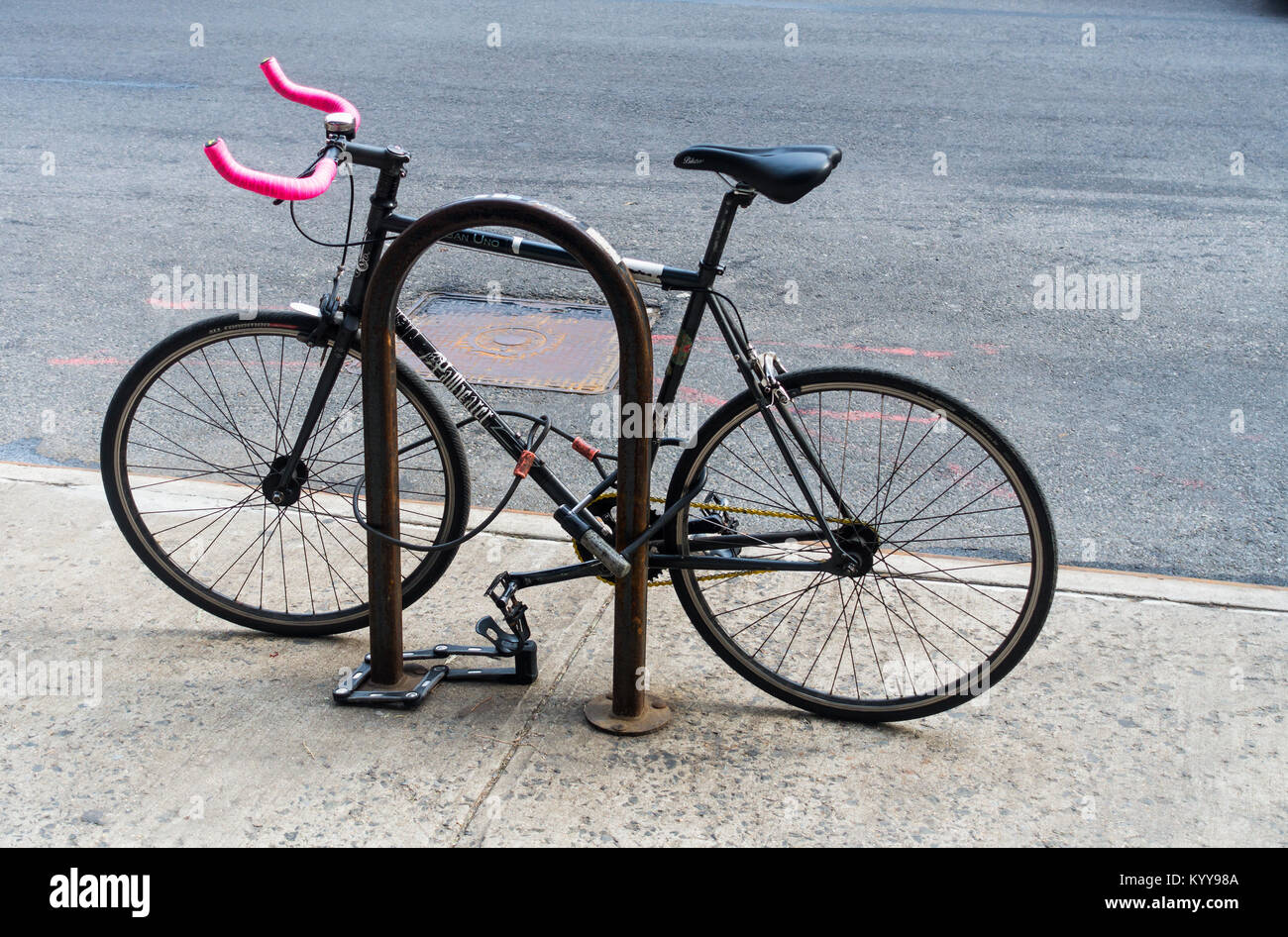 A man's racing bike secured to a bike rack in New York City Stock Photo ...