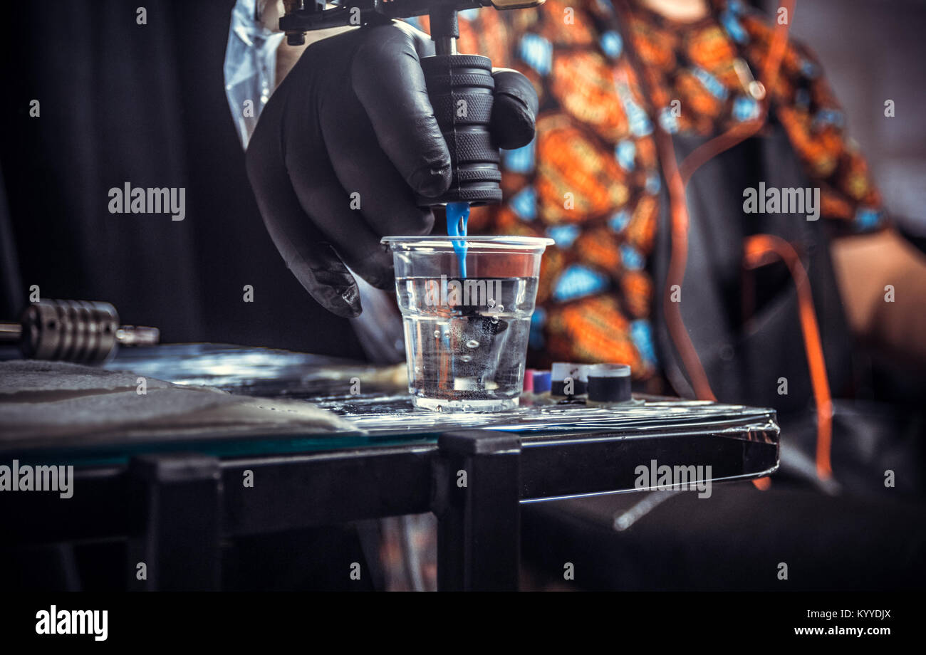 Hand of master of the art of tattooing with a tattoo gun Stock Photo ...