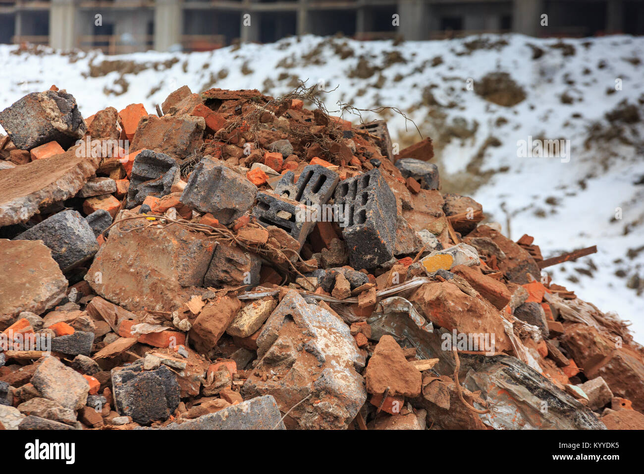 A pile of construction debris with broken bricks and concrete in winter ...