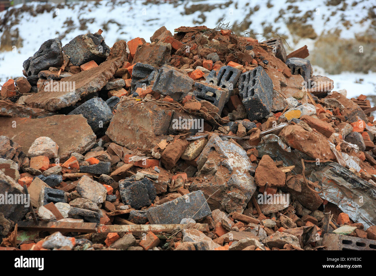 A pile of construction debris with broken bricks and concrete in winter ...