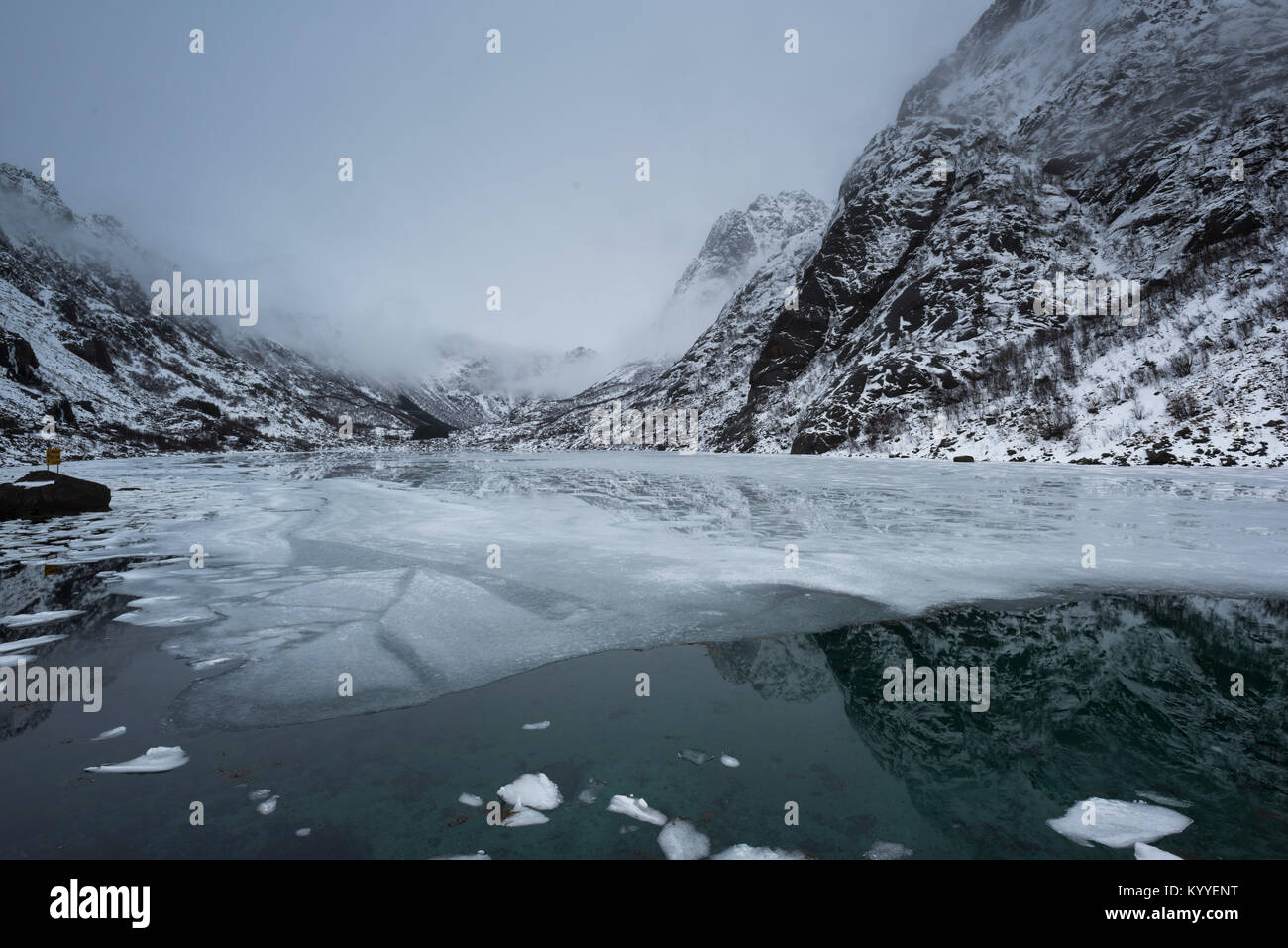 Reflection of mountains with ice floe floating in water, Lofoten ...