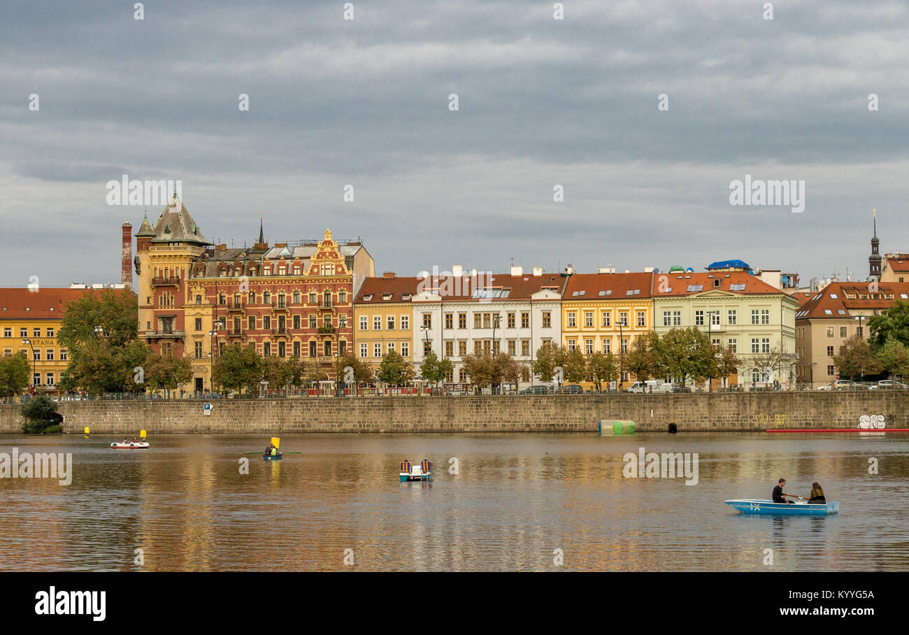 A couple rowing a boat on the River Vltava with Prague Old Town lining ...