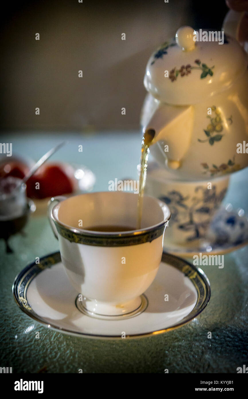 Tea pouring in a teacup from a teapot Stock Photo - Alamy