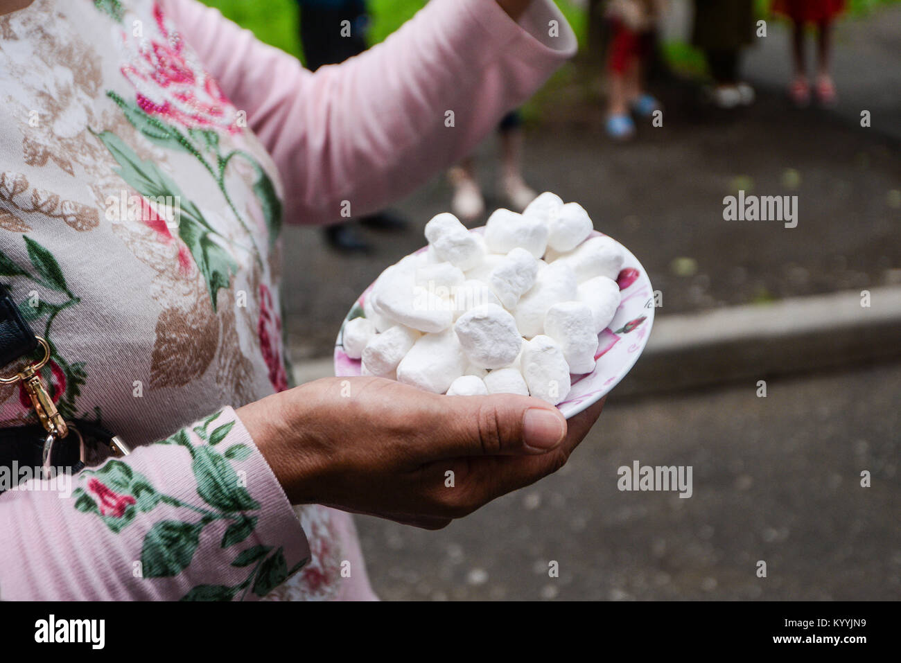 The hands of women holding pink cotton candy in the background of the ...