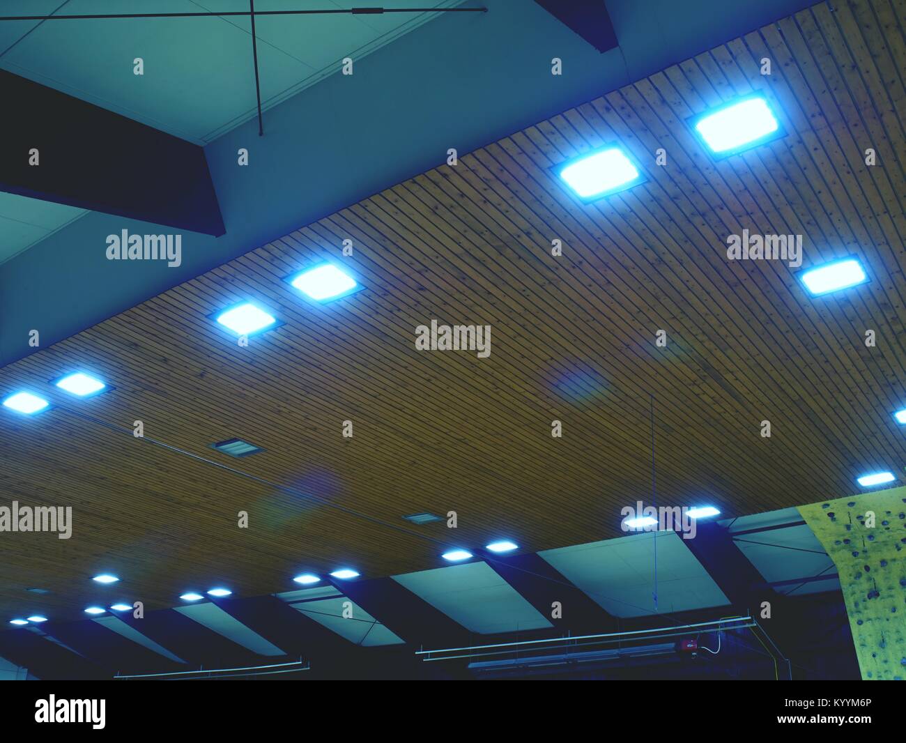 Luminous ceiling of square tiles. Wooden ceiling with lighting panels ...