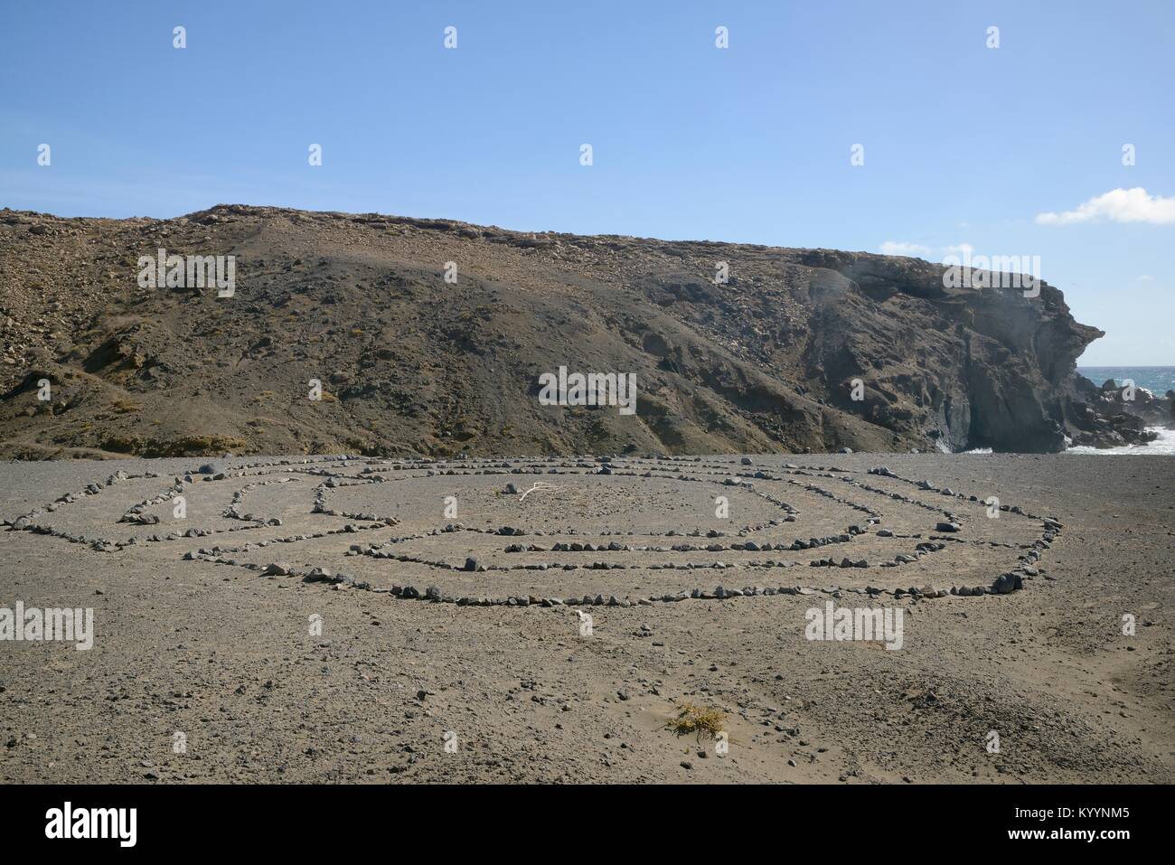 Stones arranged into a maze pattern on a bare volcanic rock headland at ...
