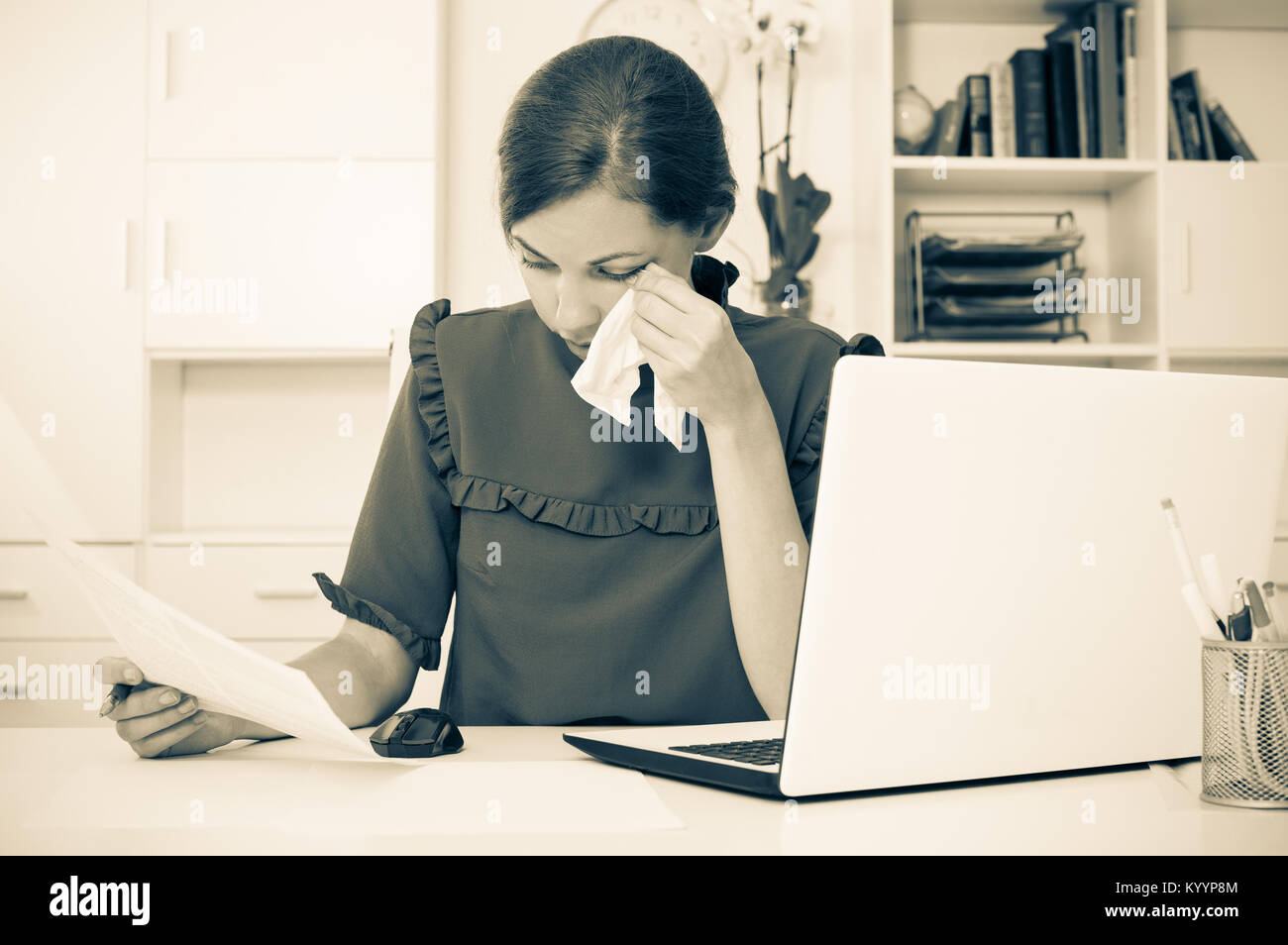 Dissapointed young woman holding documents and crying because of ...