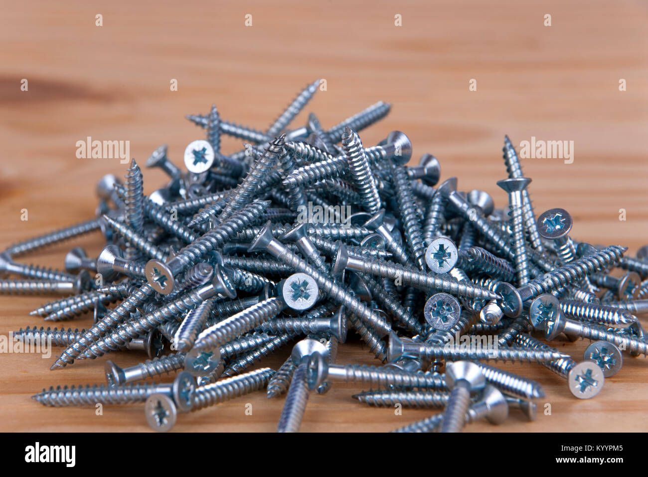 A pile of cross head wood screws on a pine board Stock Photo - Alamy