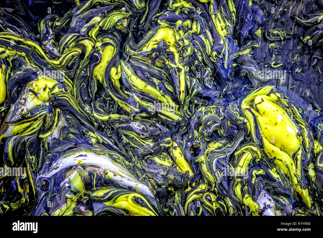 Congealed oil on water in yellow and black creating an abstract organic ...
