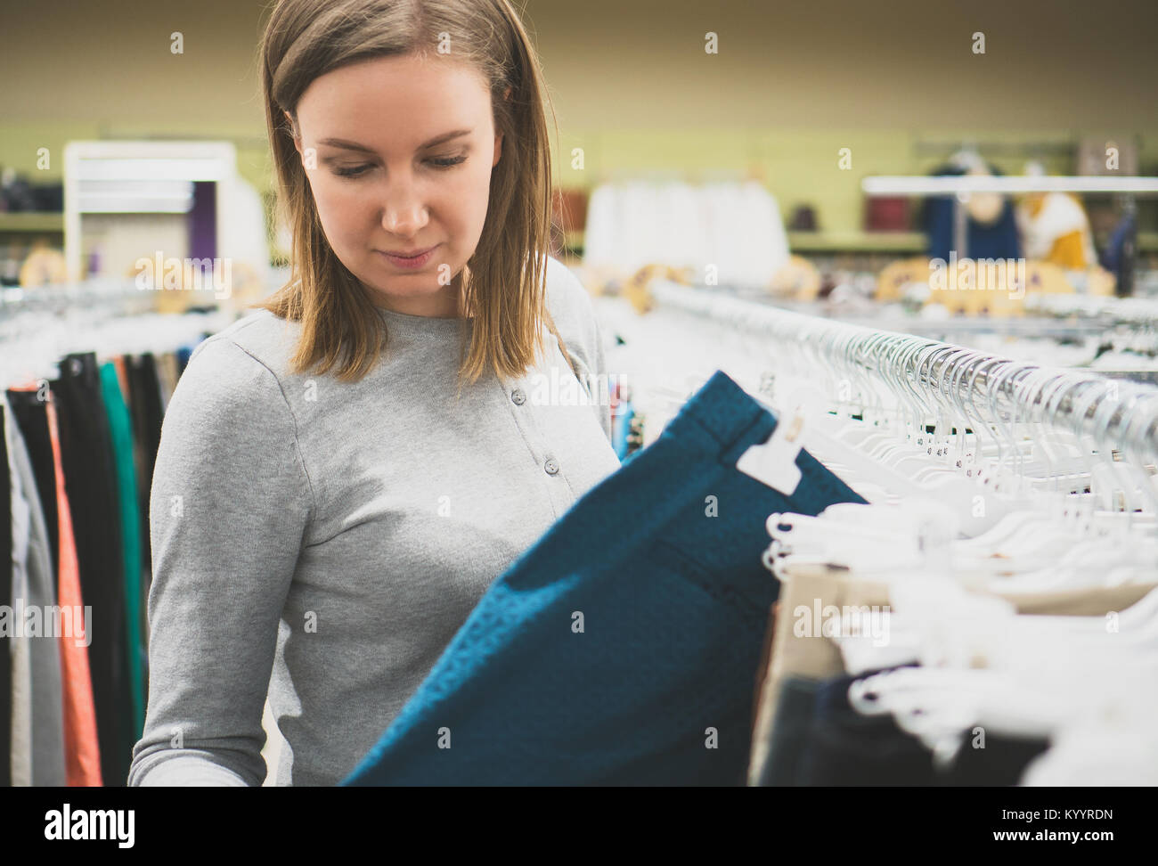 Woman choosing pants in clothing store Stock Photo - Alamy