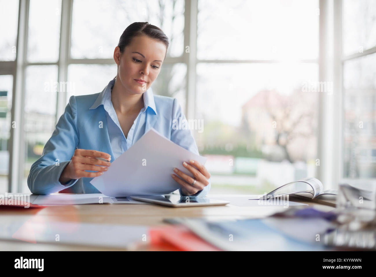 Young businesswoman reading document at office desk Stock Photo - Alamy