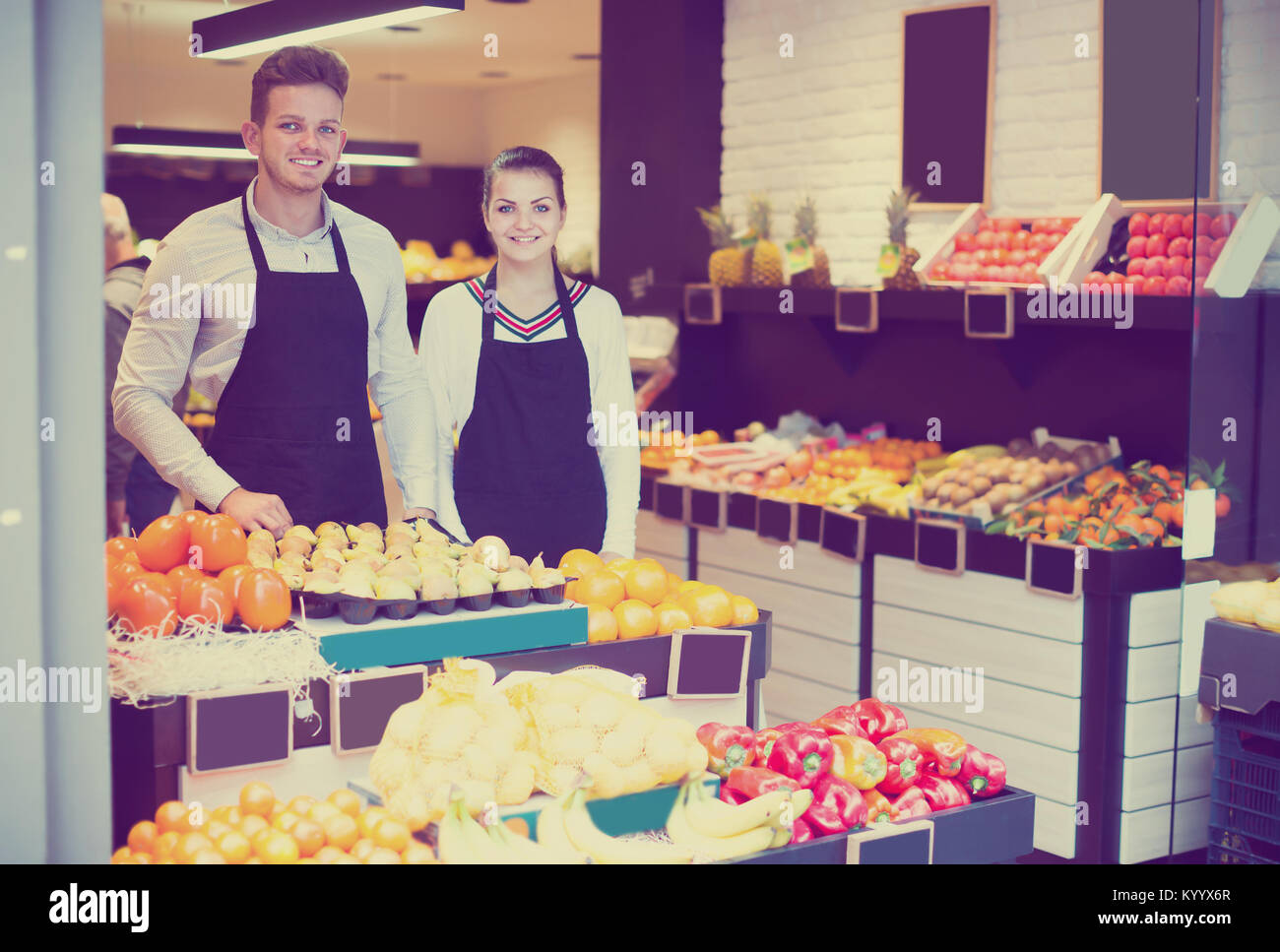 Positive shopping assistants demonstrating assortment of grocery shop ...