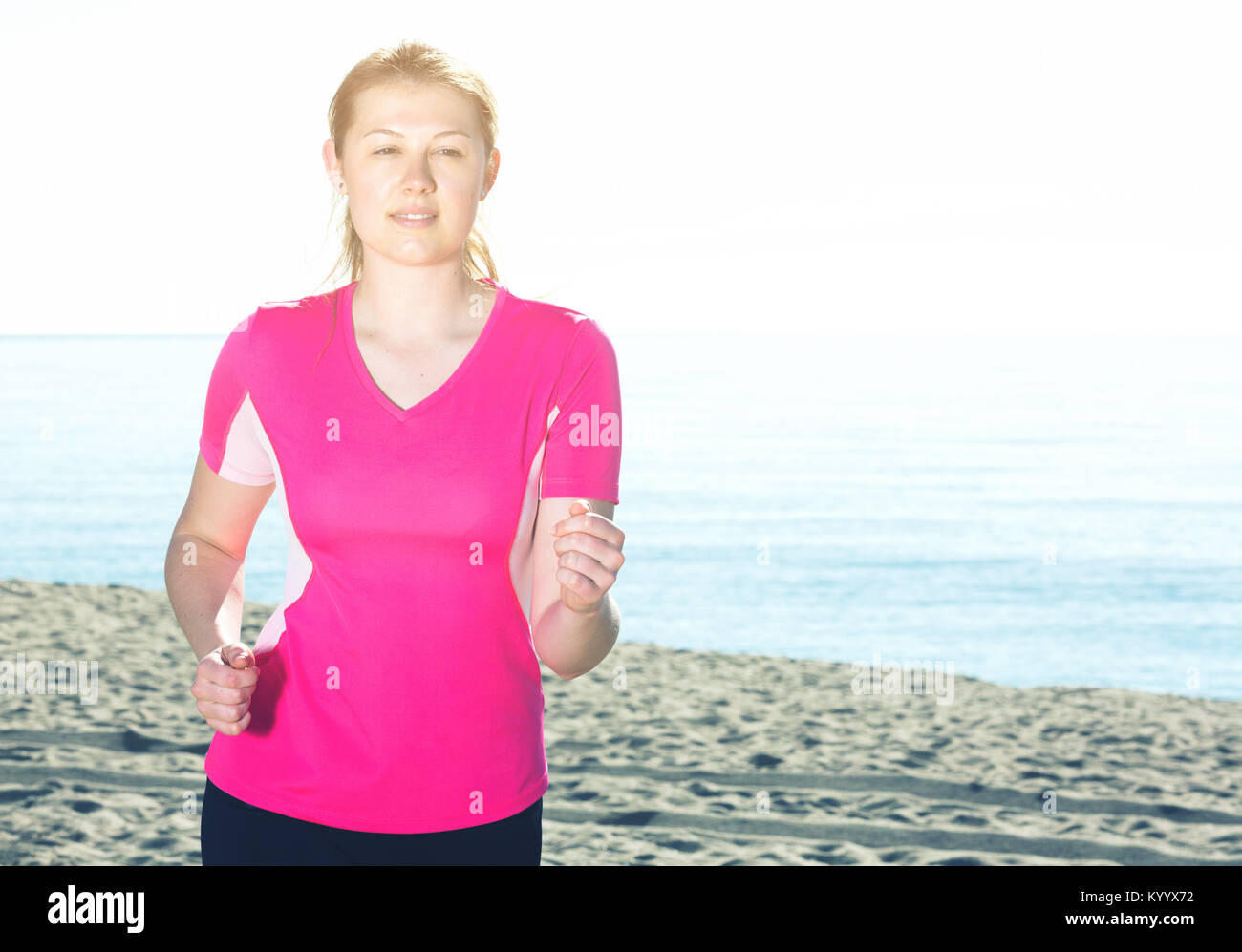 Positive svelte woman jogging during outdoor workout on beach Stock ...