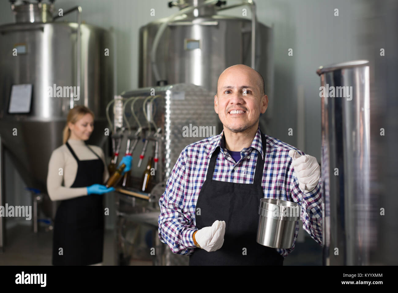Portrait of mature happy male brewery worker on beer production factory ...
