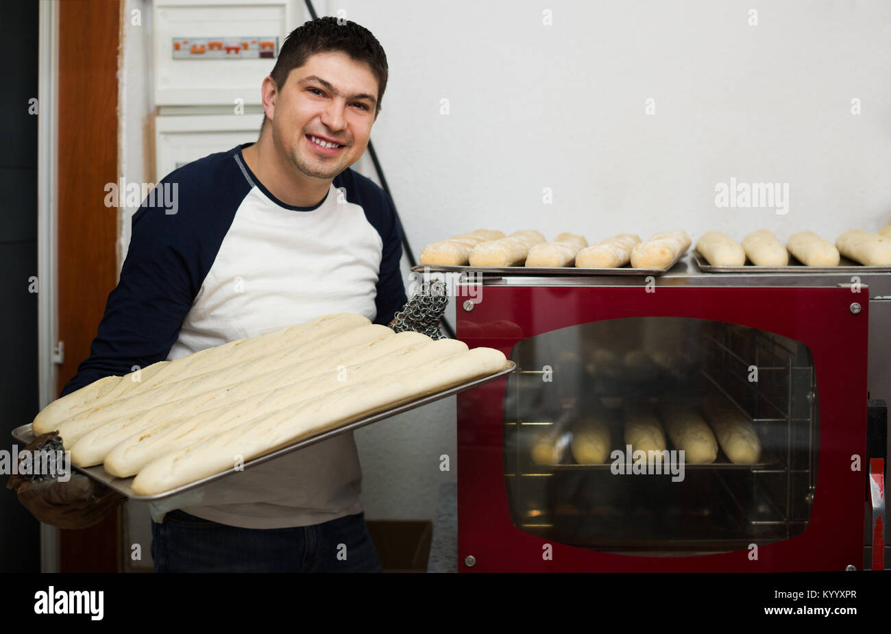 Smiling man baking fresh bread at grocery store Stock Photo - Alamy