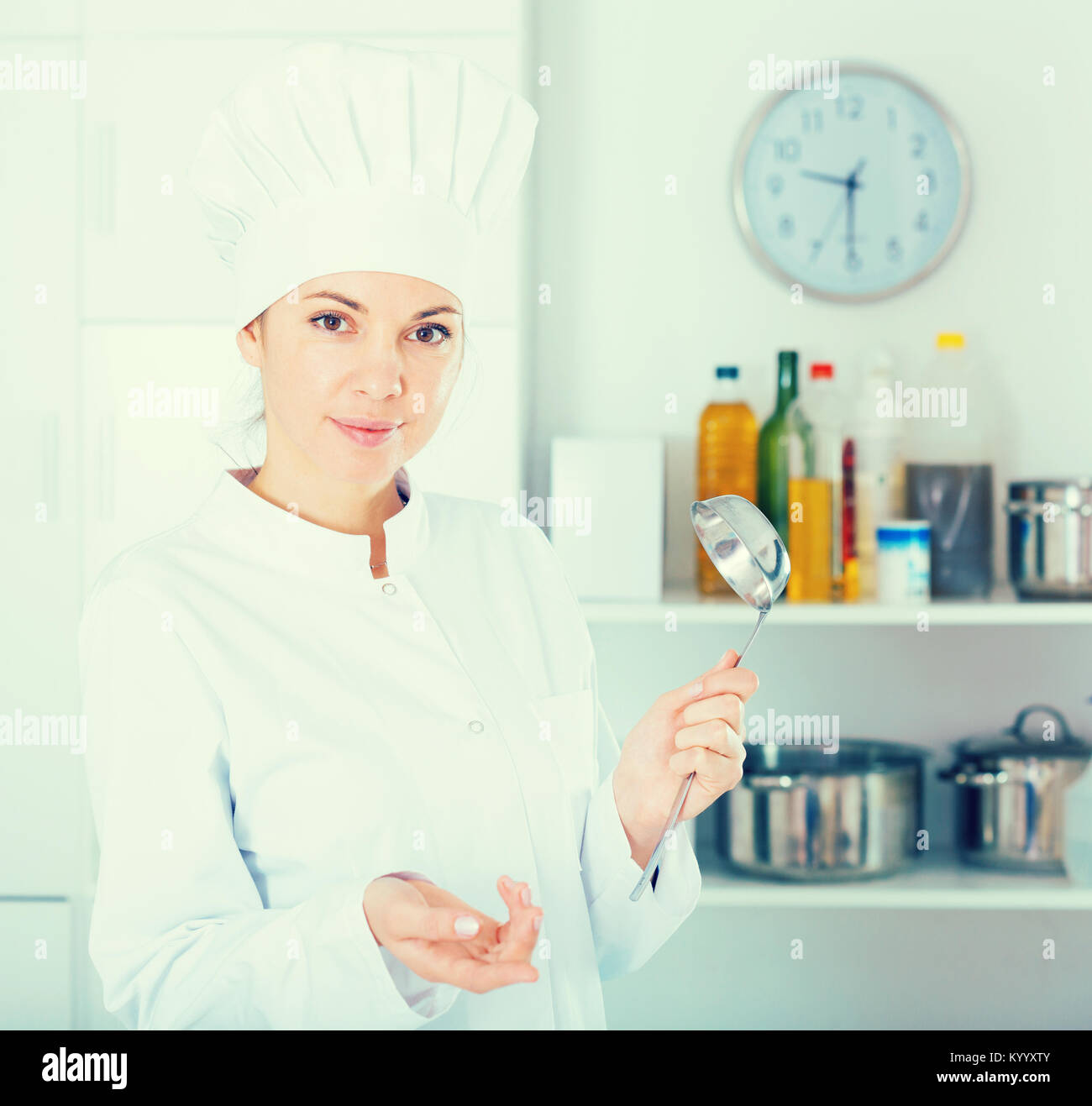 Smiling female cook practicing her skills in kitchen Stock Photo - Alamy