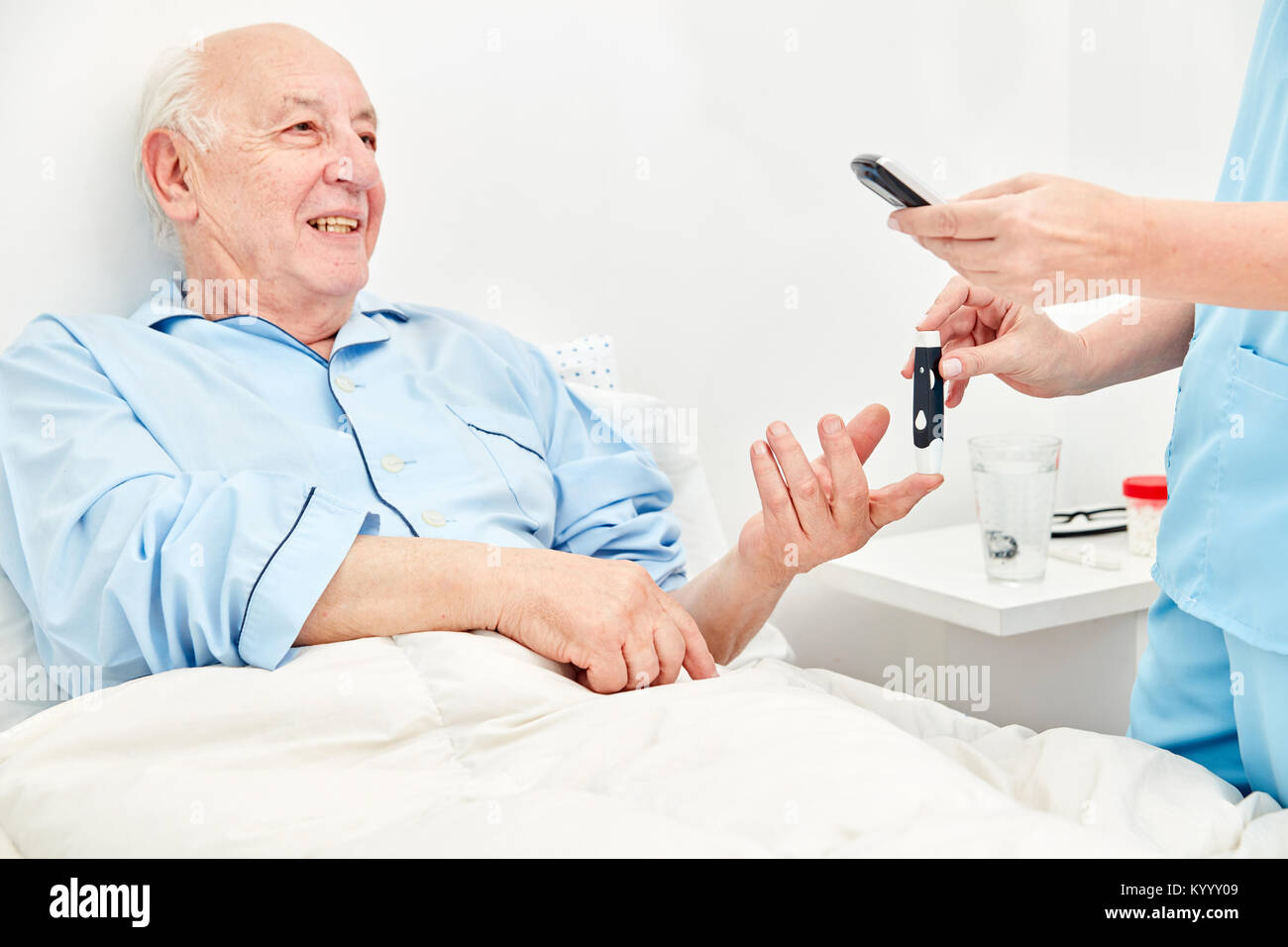 Nurse makes blood glucose measurement in senior as a patient with ...