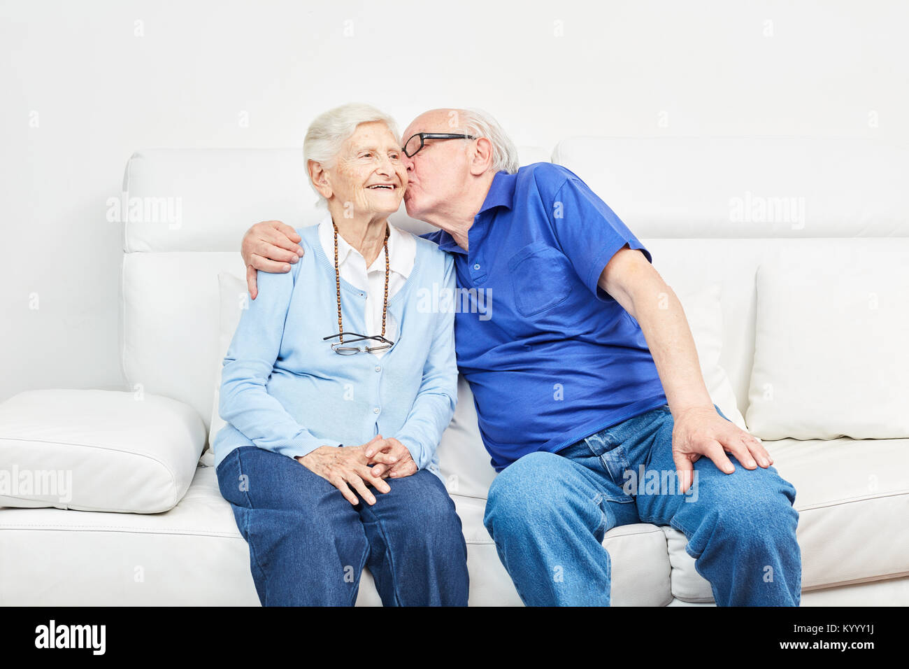 Happy couple kissing on sofa hi-res stock photography and images - Alamy