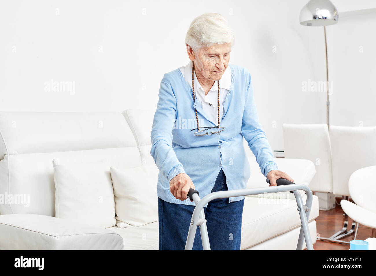 Senior as a patient with handicap learns to walk with the walking frame ...