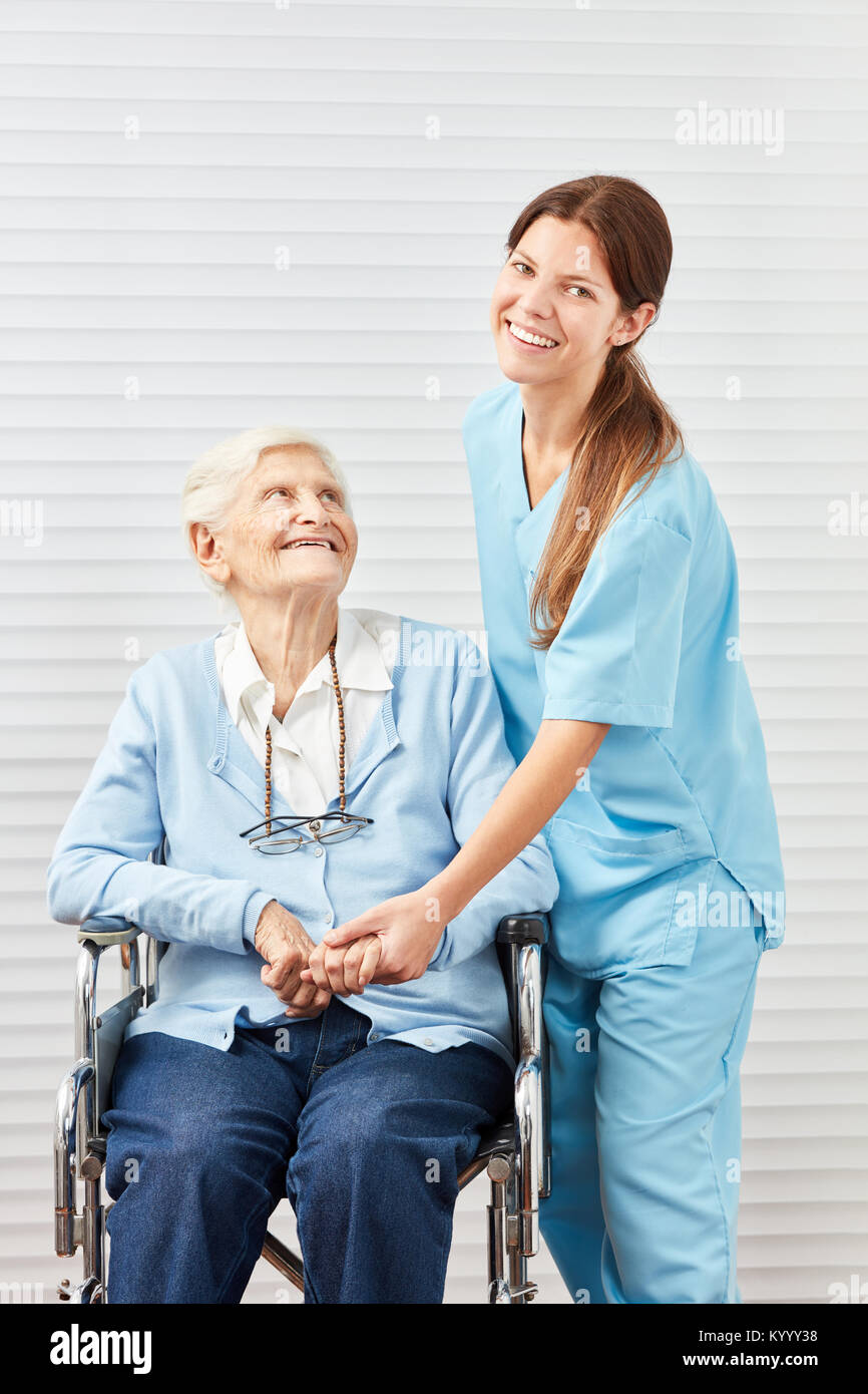 Young woman as a geriatric nurse and a senior citizen in a wheelchair ...