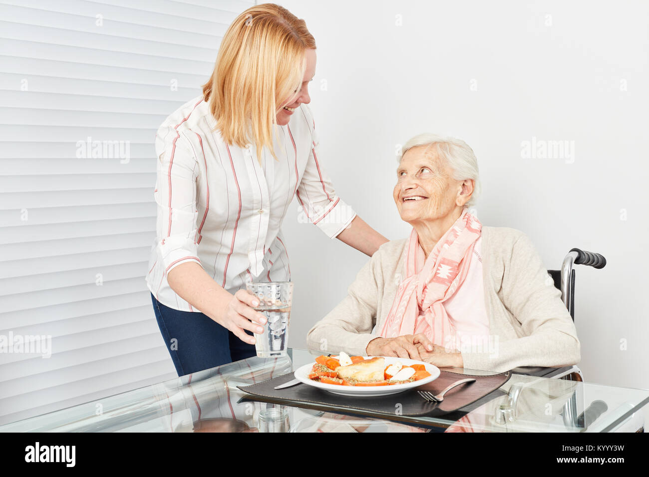 Nursing lady serves old woman a meal in a nursing home or at home Stock ...