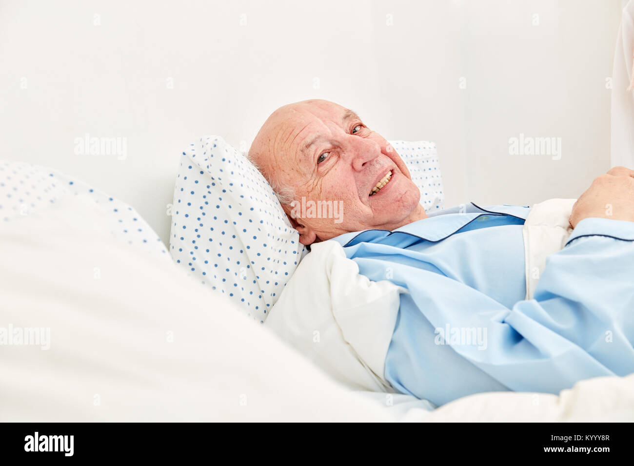 Senior is sick and frail in bed as a patient in a nursing home or ...