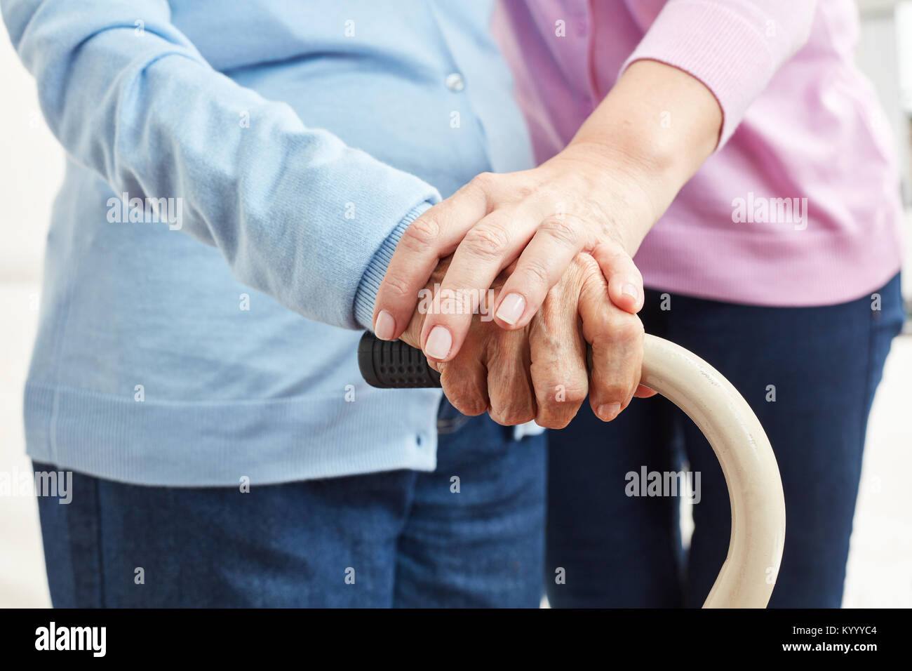 Hand of a young woman touches hand of a senior citizen as comfort and ...