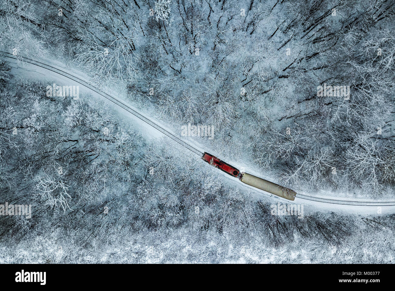 Budapest, Hungary - Aerial view of snowy forest with red train on a ...