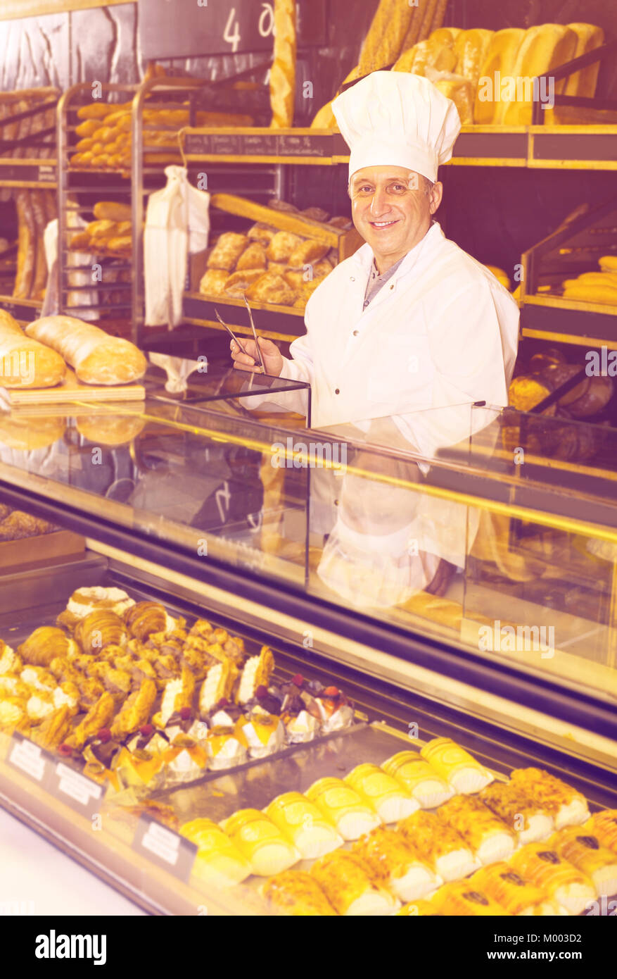 american male staff offering fresh pastry in sweet-shop Stock Photo - Alamy