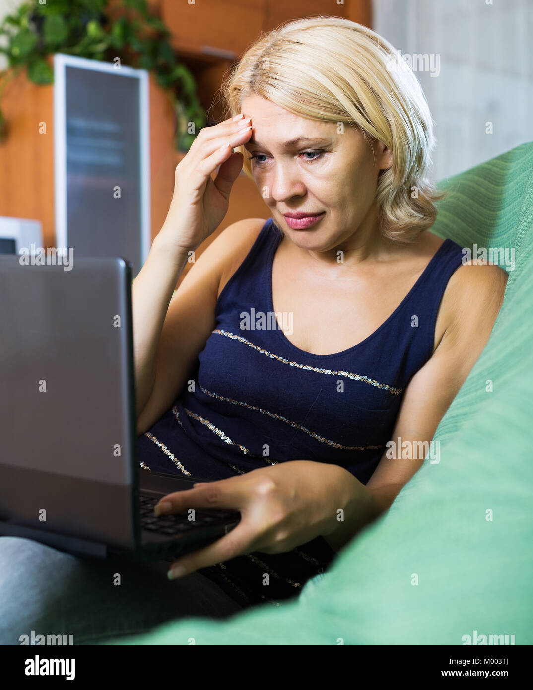 Crying elderly woman receiving bad news in internet Stock Photo - Alamy