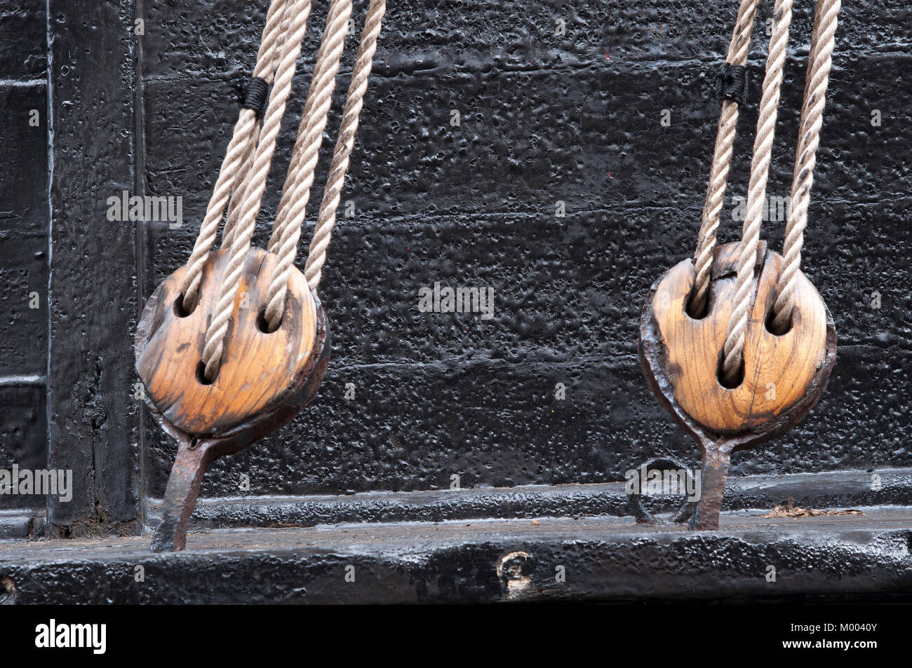 Two deadeyes or bull's eyes strung with line on the side of an old ...