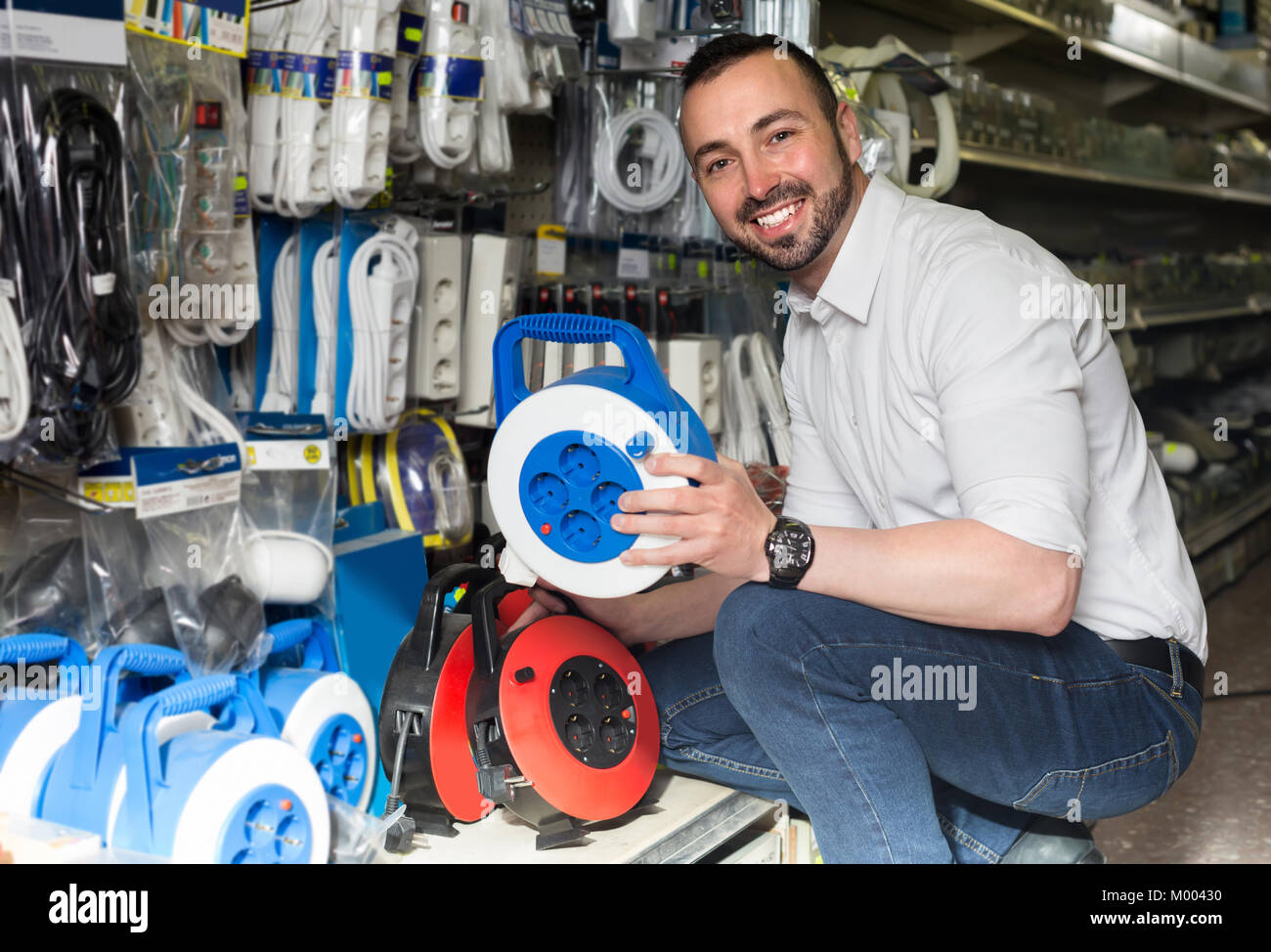 Portrait of smiling male customer selecting electric round extender ...