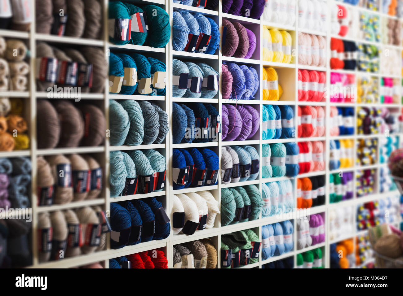 Shelves with assortment beauty colorful wool and yarn in knitting shop ...