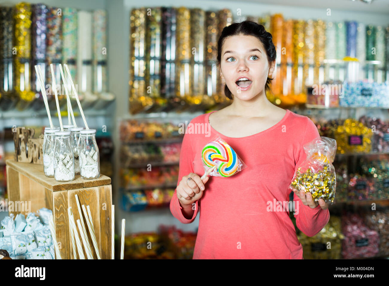 Happy brunette girl buying candies at shop Stock Photo - Alamy
